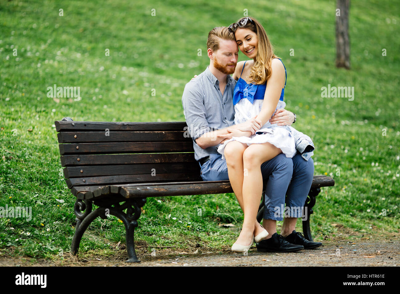 Romantic couple in park sitting on bench Stock Photo - Alamy