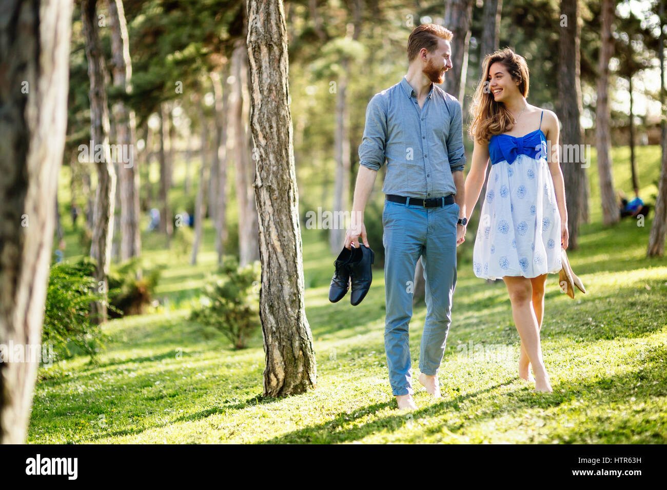 Couple enjoying romantic walk in nature barefoot Stock Photo - Alamy