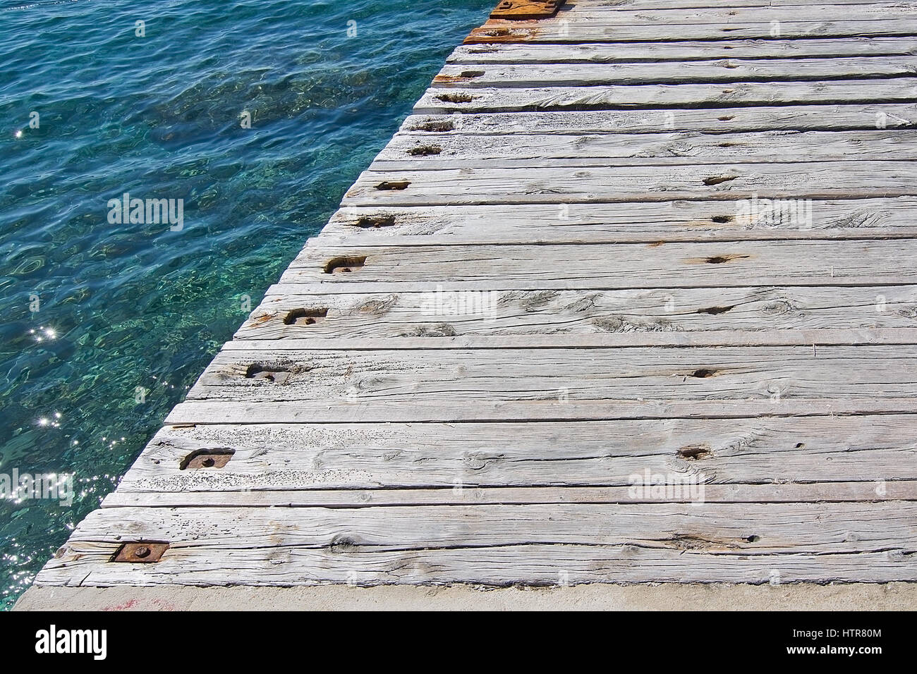 Rustic wood pier with nails and clear green water background texture ...