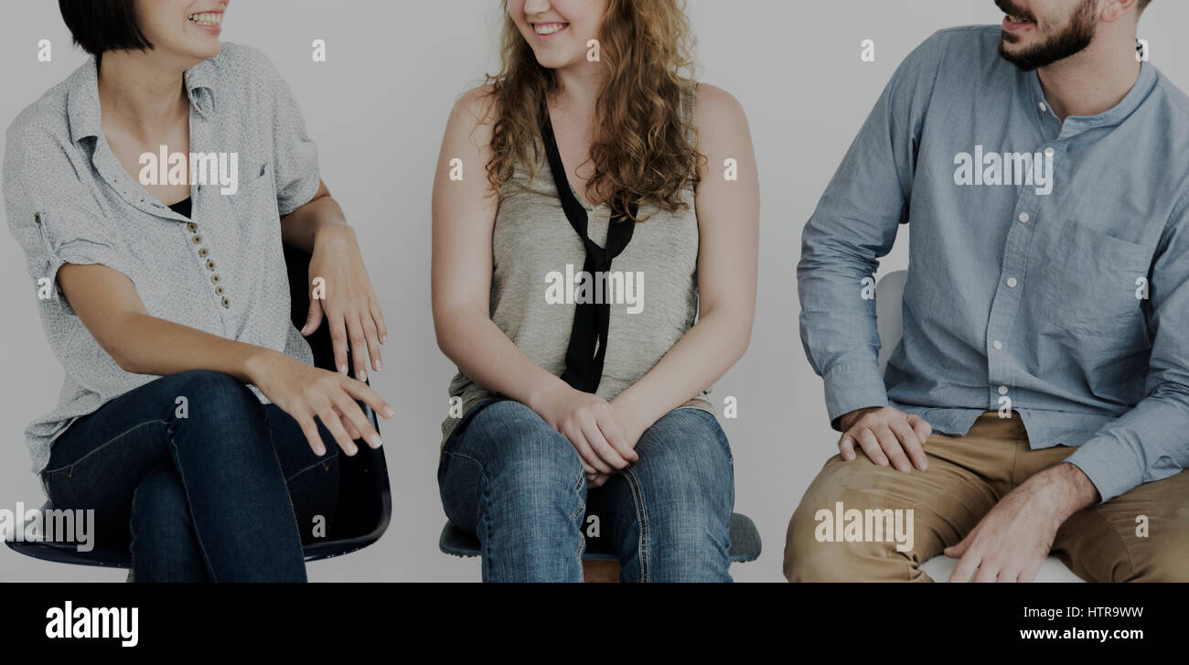 Group of cheerful people sitting in a row Stock Photo - Alamy