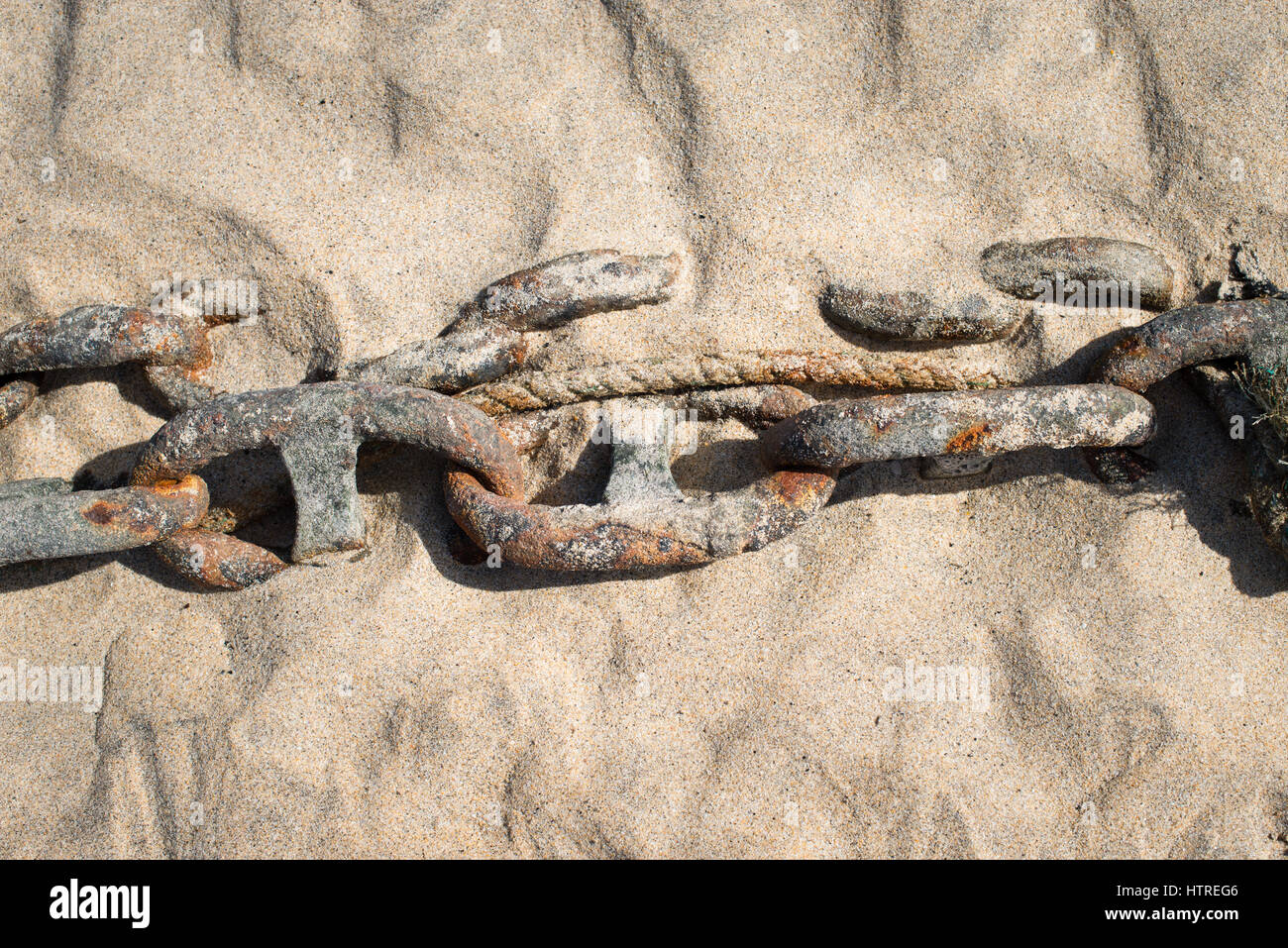 A rusty metal chain on a sandy beach Stock Photo - Alamy