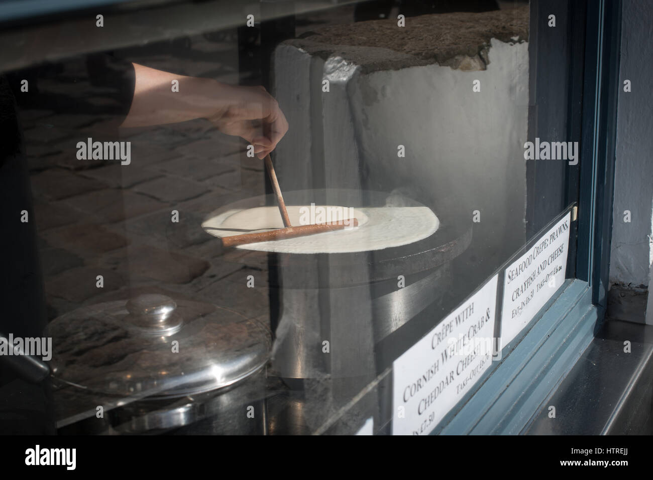 A crepe is prepared in the window of a cafe in St Ives, Cornwall ...