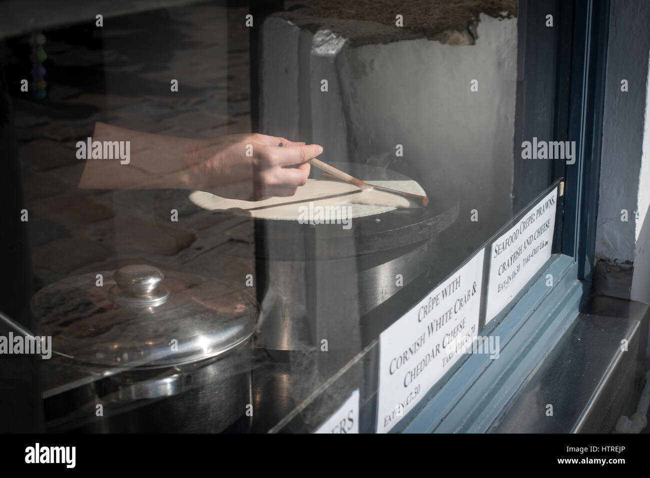 A crepe is prepared in the window of a cafe in St Ives, Cornwall ...