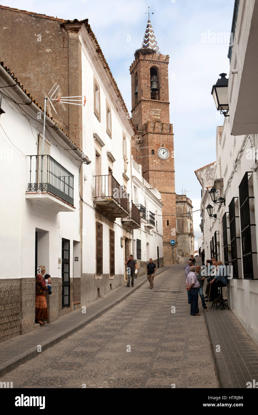 Church of Our Lady of the Assumption and people in village street ...