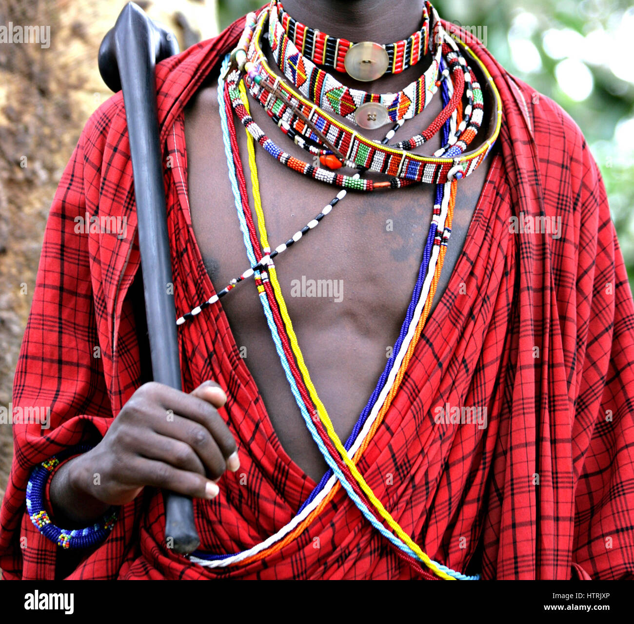 Masai warrior showing elaborate, colourful beadwork. Man carrying a ...