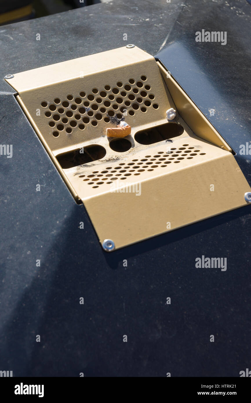 Cigarette stub and chewing gum in an outdoor garbage or rubbish bin ...