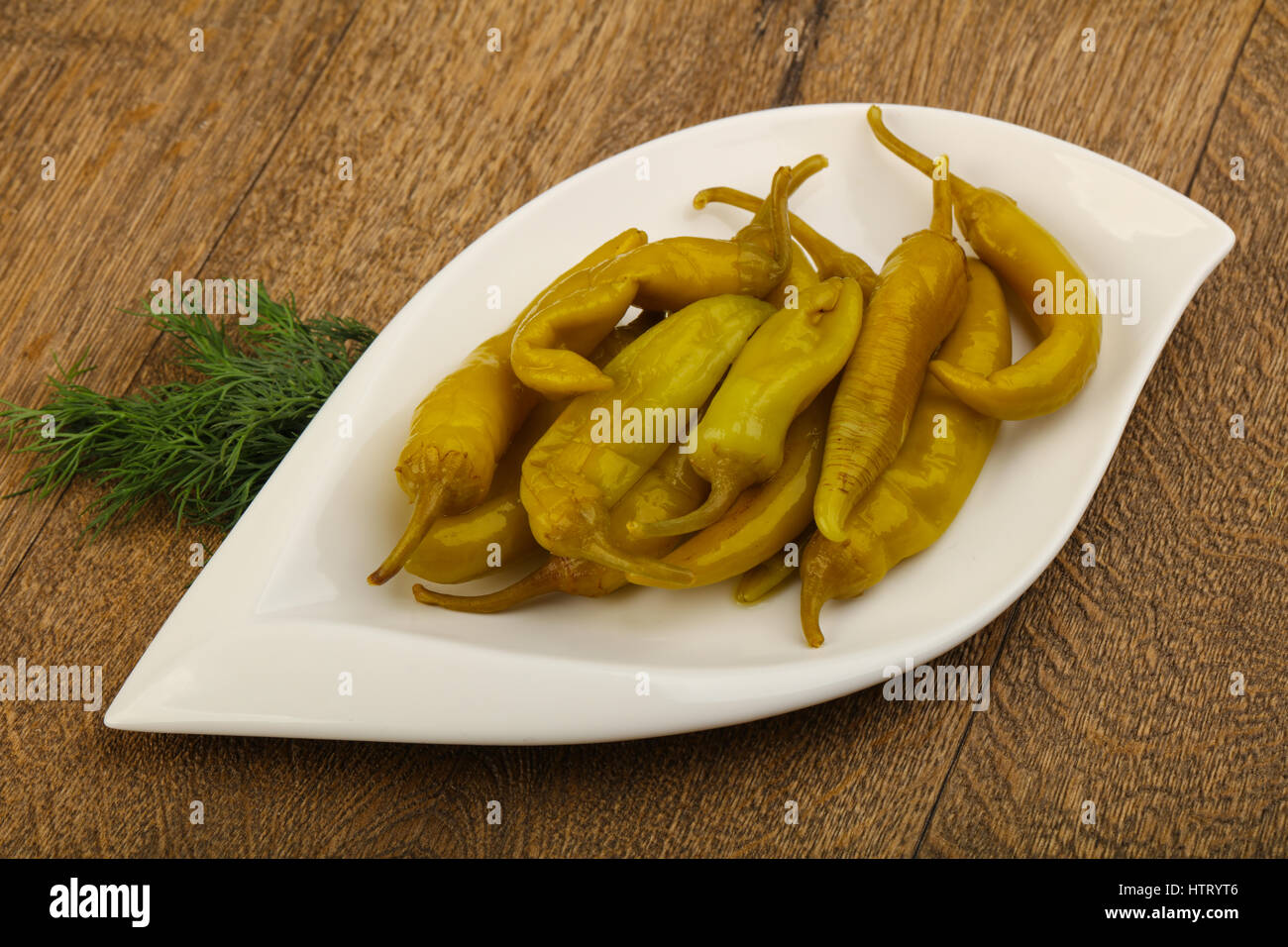 Pickled green pepperoni pepper in the bowl on wood background Stock ...