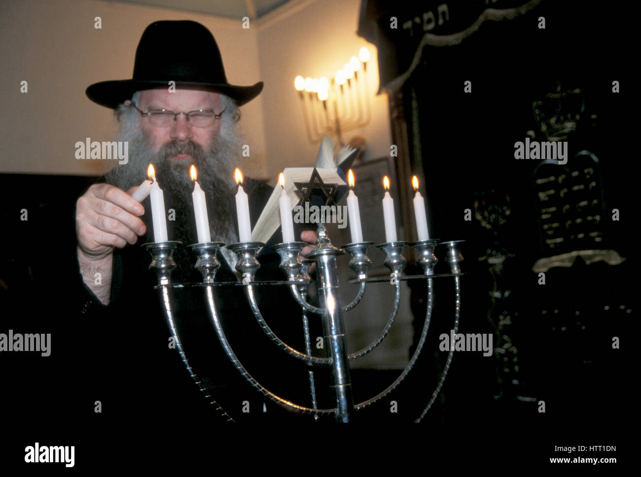 Rabbi lighting menorah Hanukah Stamford Hill North London Stock Photo ...
