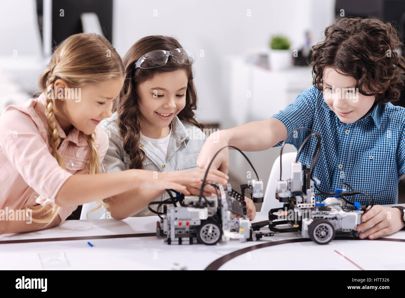 Cheerful kids working on the tech project at school Stock Photo - Alamy