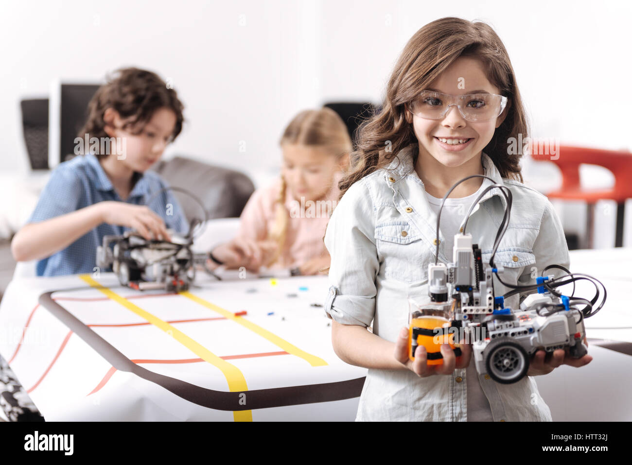 Optimistic girl demonstrating tech project at school Stock Photo - Alamy