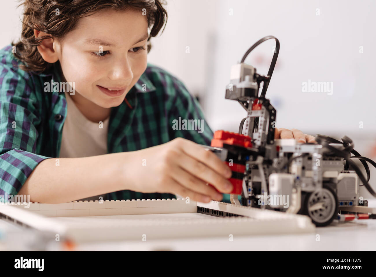 Capable teen kid constructing robot in the studio Stock Photo - Alamy