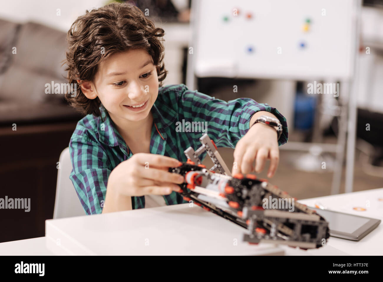 Amused teen boy programming digital robot in the studio Stock Photo - Alamy