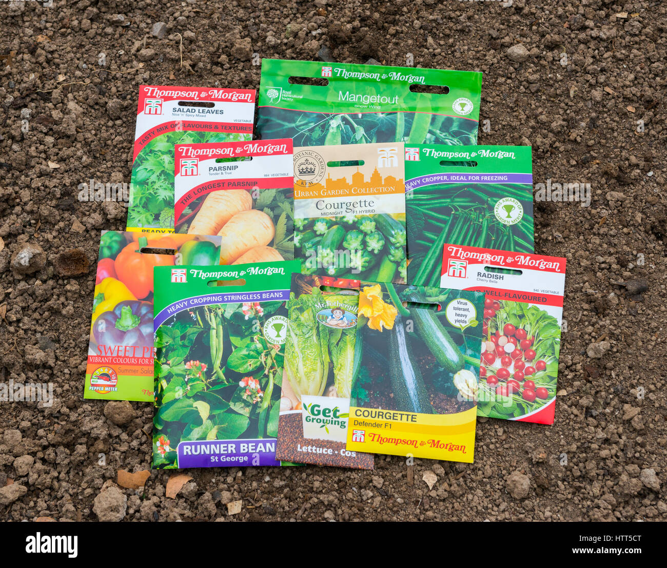 Packets of vegetable seeds on a bed of soil Stock Photo - Alamy
