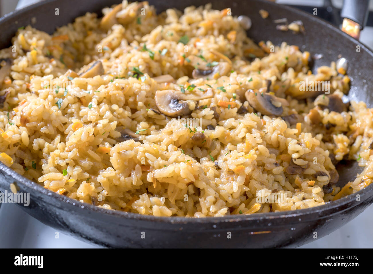Rice with mushrooms and carrot or pilaf in frying pan Stock Photo - Alamy