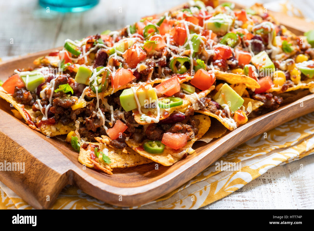 Mexican nacho yellow corn tortilla chips with cheese, meat, avocado ...