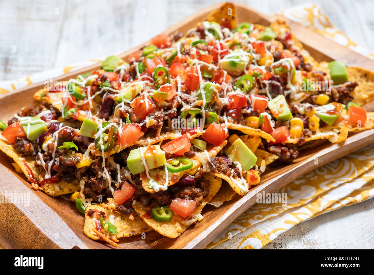 Mexican nacho yellow corn tortilla chips with cheese, meat, avocado ...