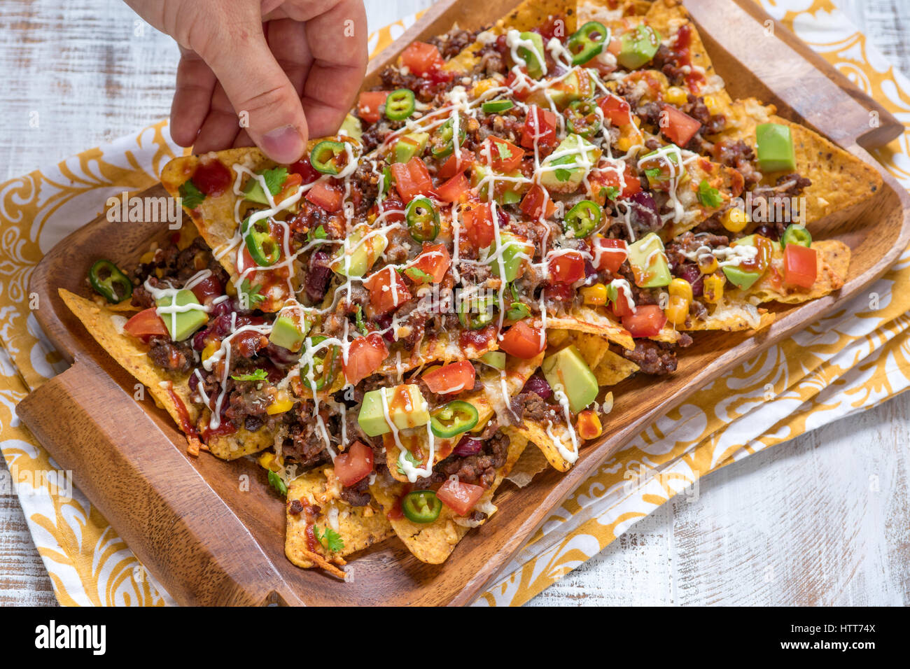 Mexican nacho yellow corn tortilla chips with cheese, meat, avocado ...