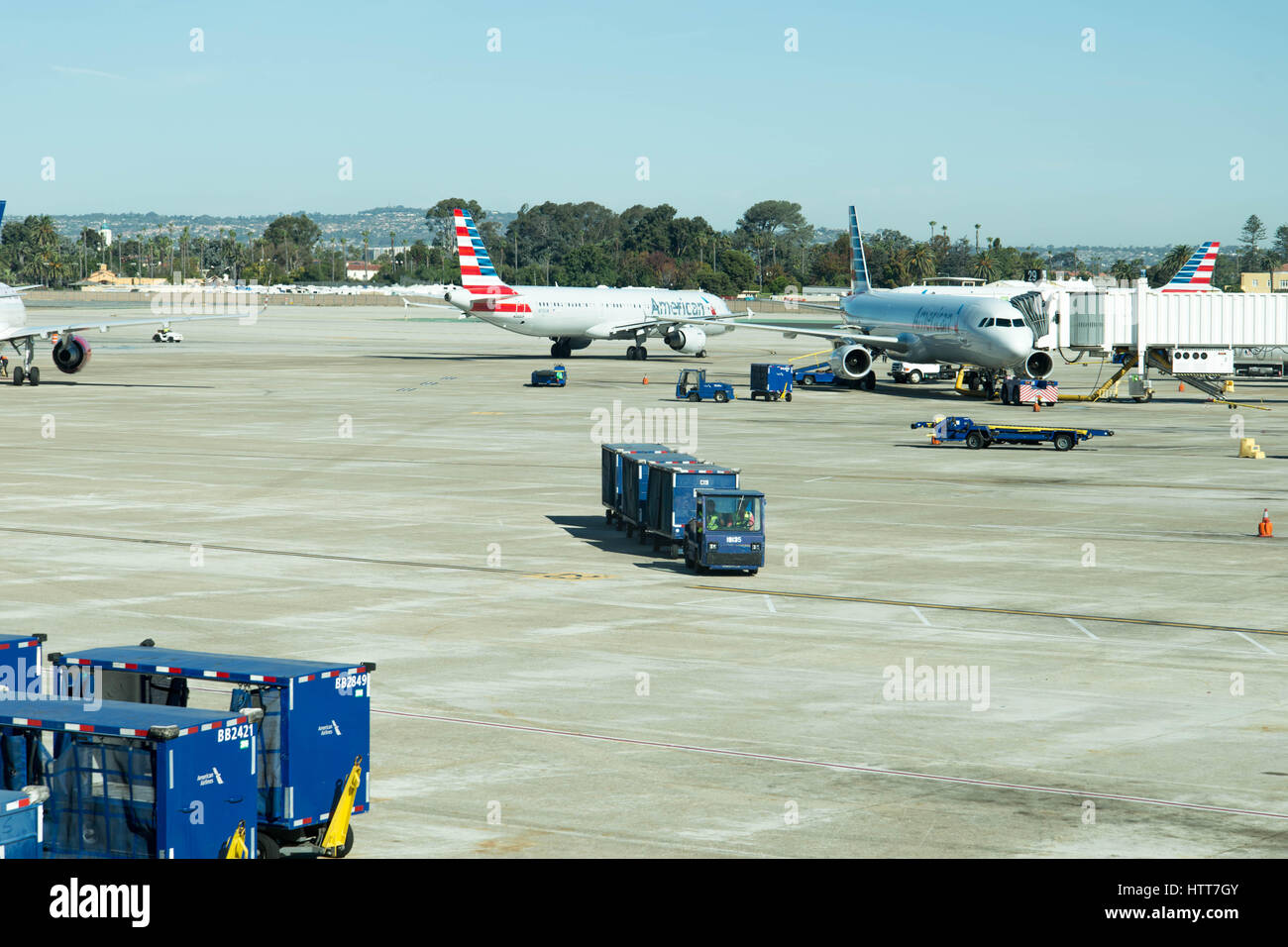 Airplanes and baggage carts on the ramp at San Antonio airport Stock ...