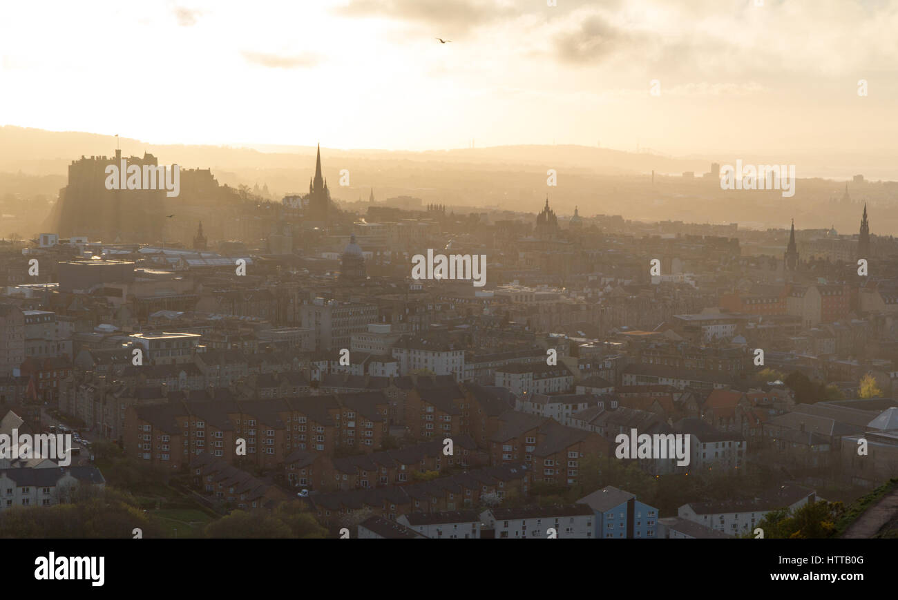 Sun rays streak past Edinburgh castle casting the city in a warm sepia ...