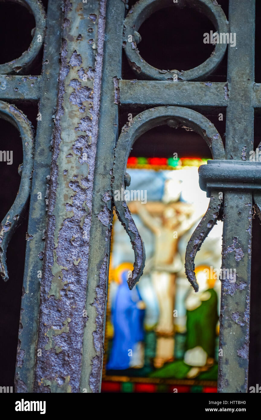 Closeup of rusty mausoleum gate with stained glass on background, in ...