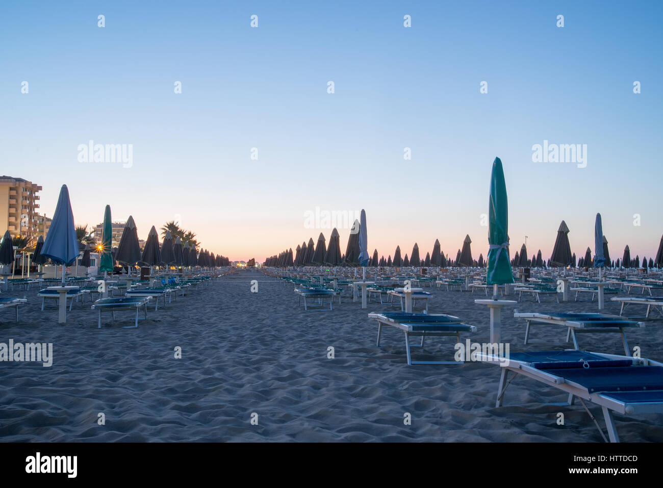 Deserted beach in the morning sun. The beach at dawn. Empty sunbeds ...