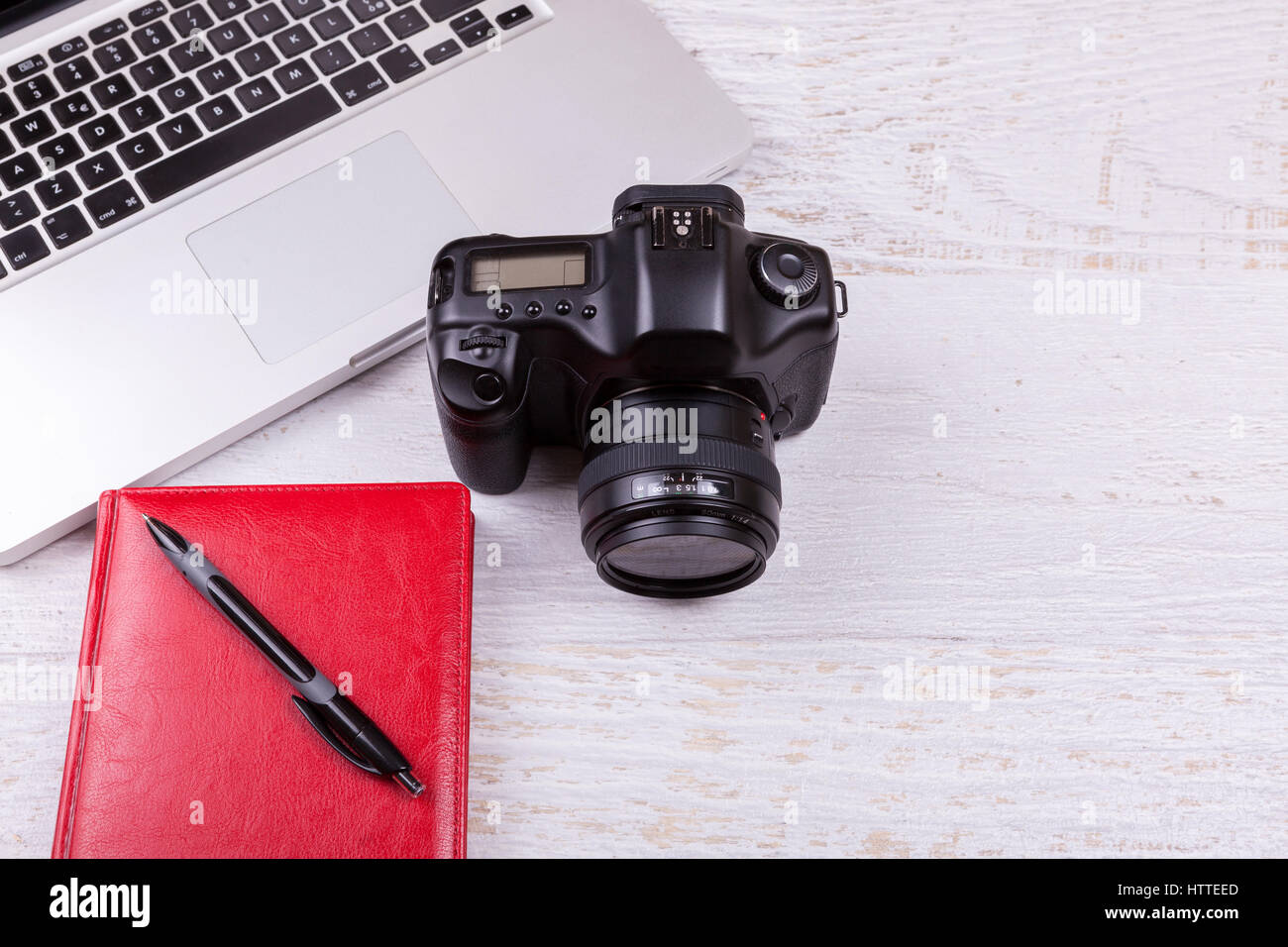 Over top photo of DSLR digital camera and laptop on wooden background ...