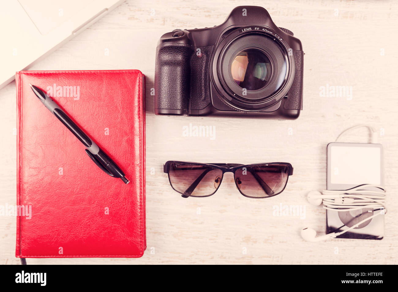 Camera, laptop, digital tabler, writing notebook and sunglasses on ...
