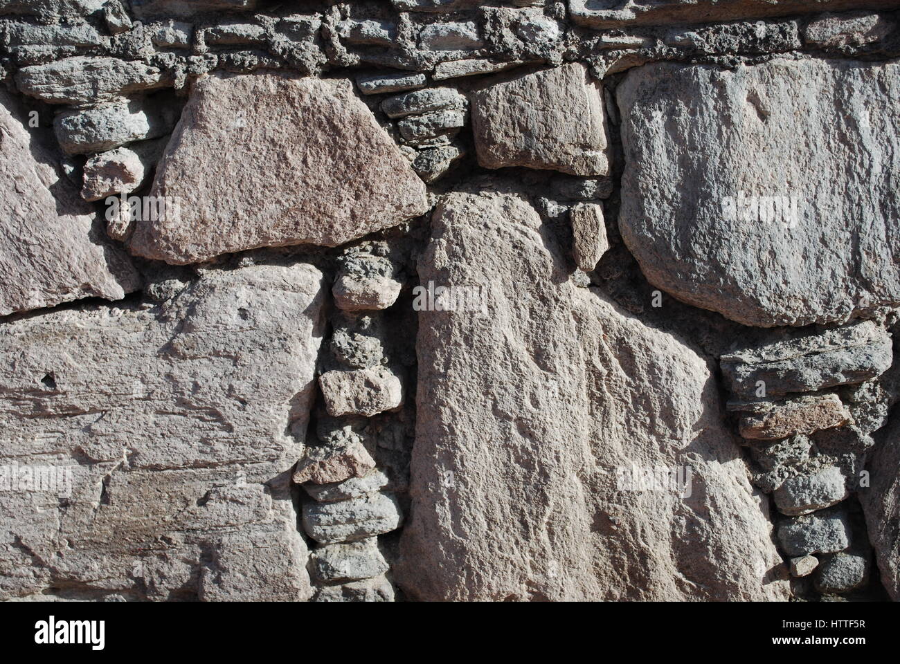 Wall of small and large stones. Background Stock Photo - Alamy