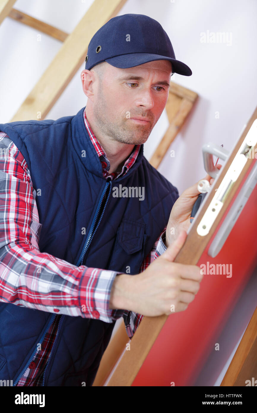 male carpenter worker at interior wood door lock installation Stock ...