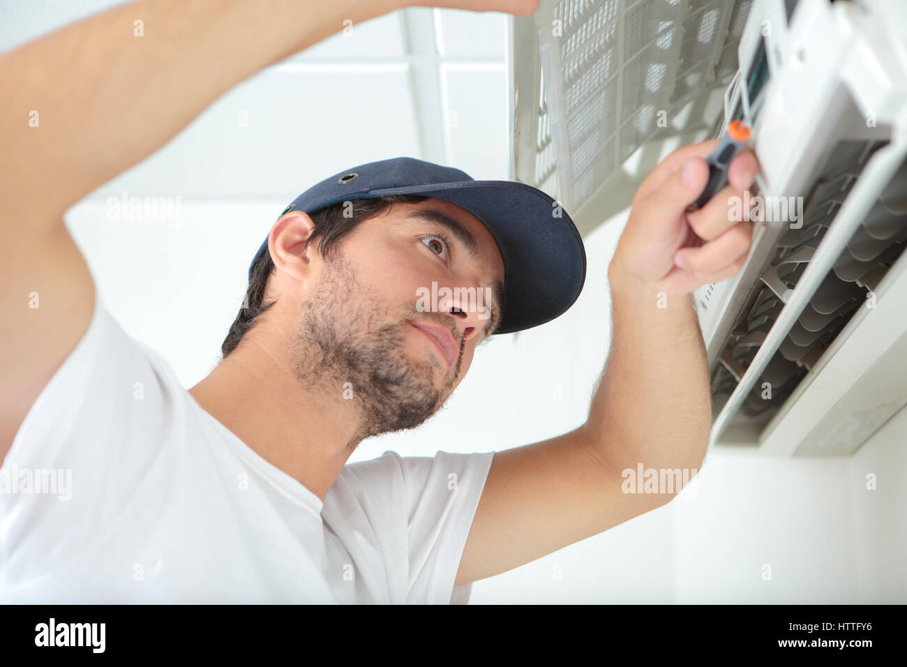 Man repairing air conditioner Stock Photo - Alamy