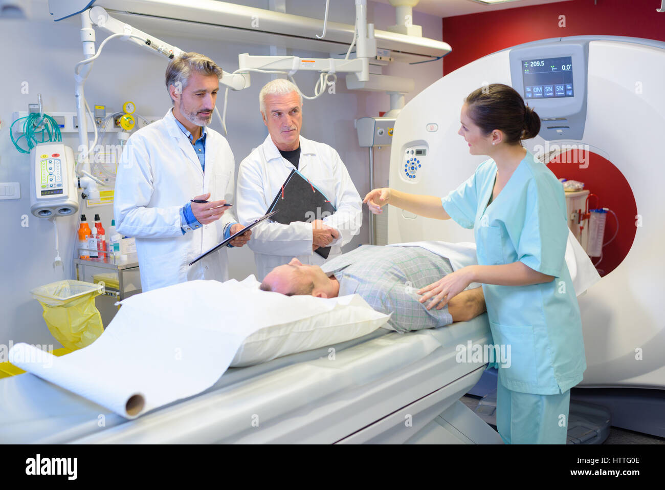 Medical staff stood around patient having scan Stock Photo - Alamy