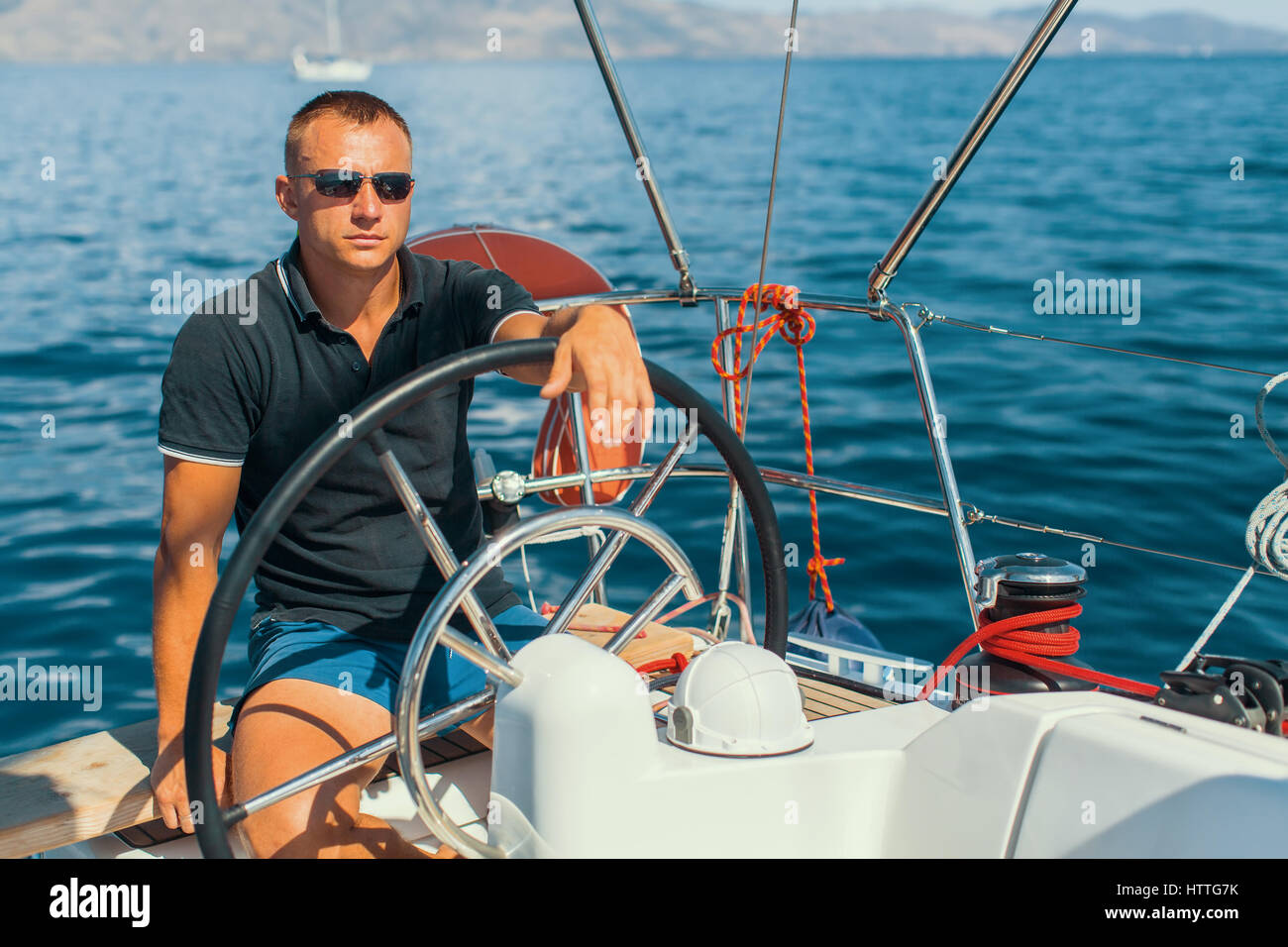 Man on his sailing yacht boat Stock Photo - Alamy
