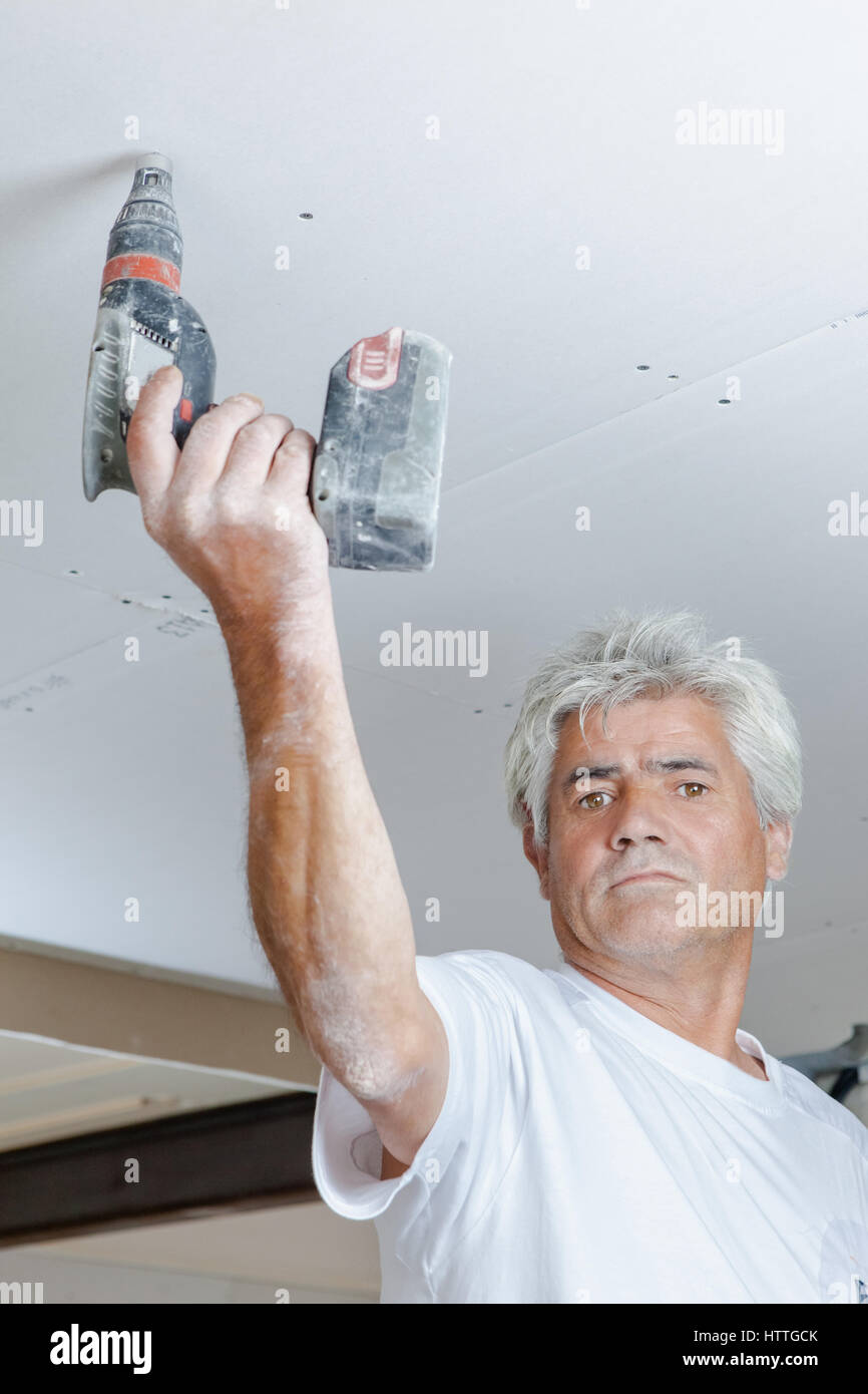 Mason drilling into the ceiling Stock Photo - Alamy