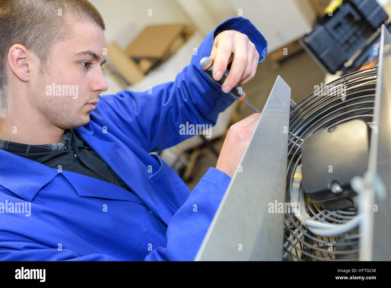 a young man repairing a fan Stock Photo - Alamy