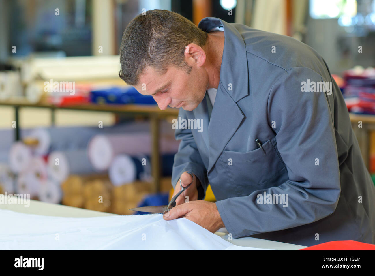 Man cutting fabric Stock Photo - Alamy