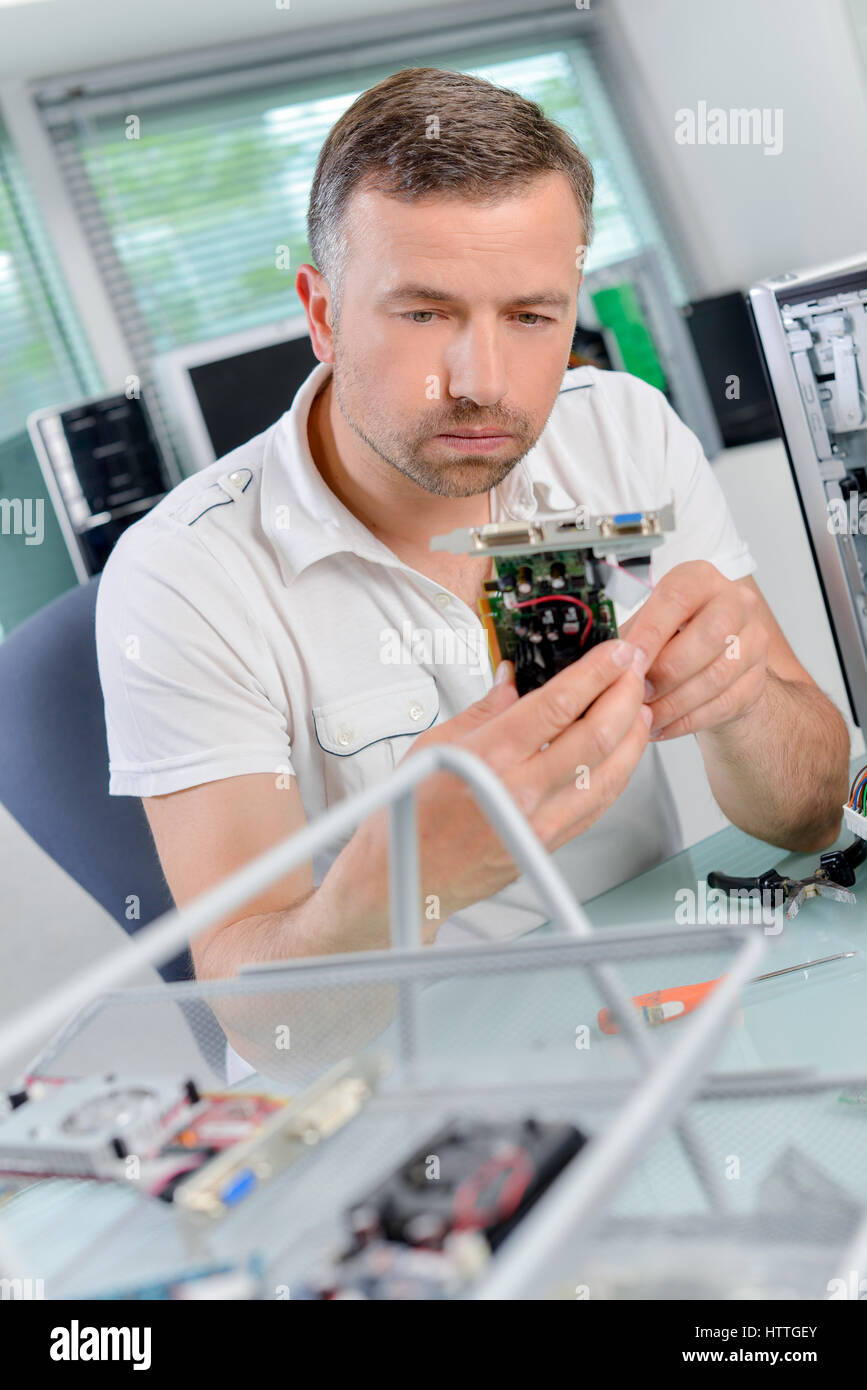 Man looking at computer component, frustrated expression Stock Photo ...
