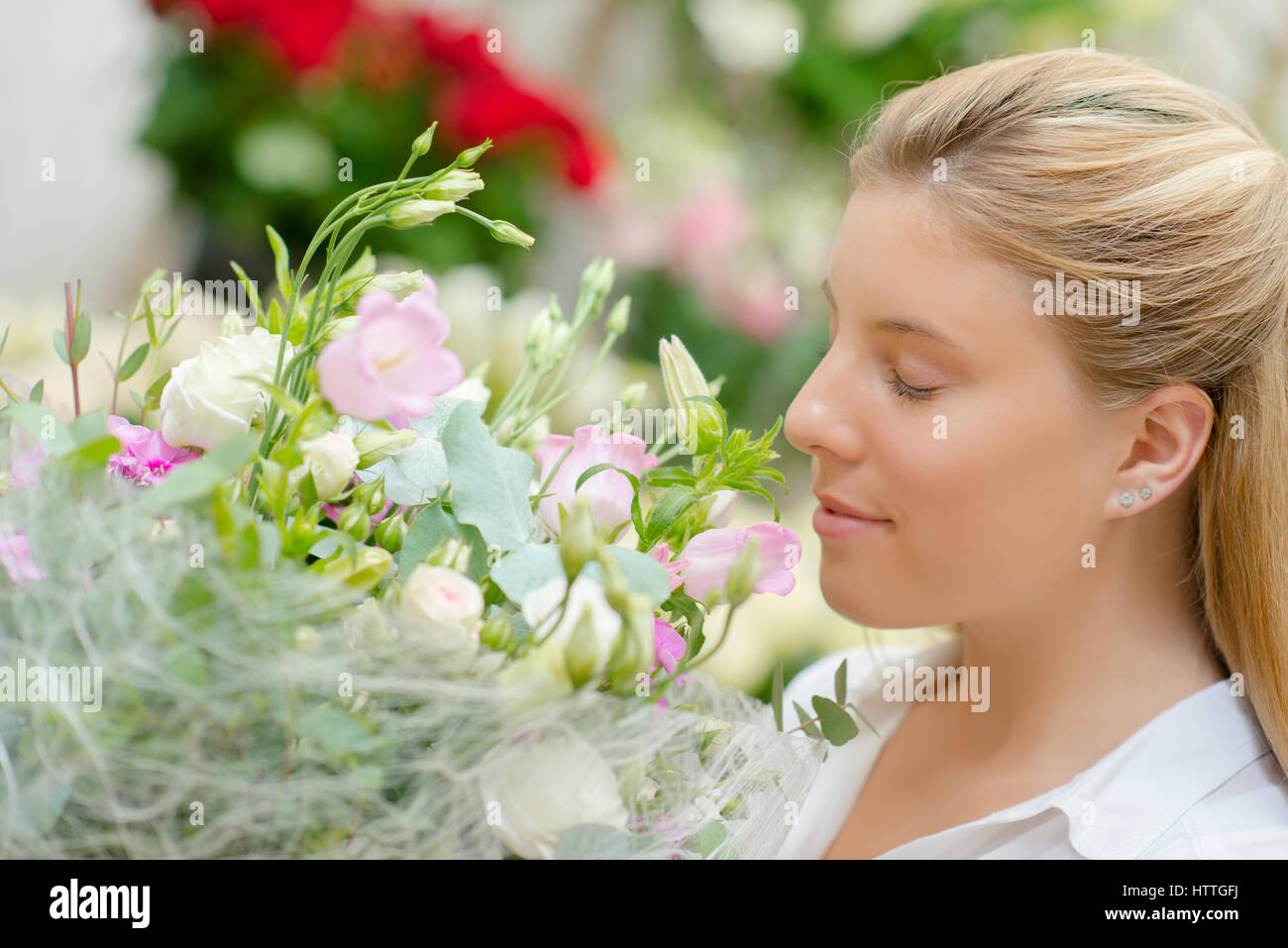 Lady smelling bouquet of flowers Stock Photo - Alamy