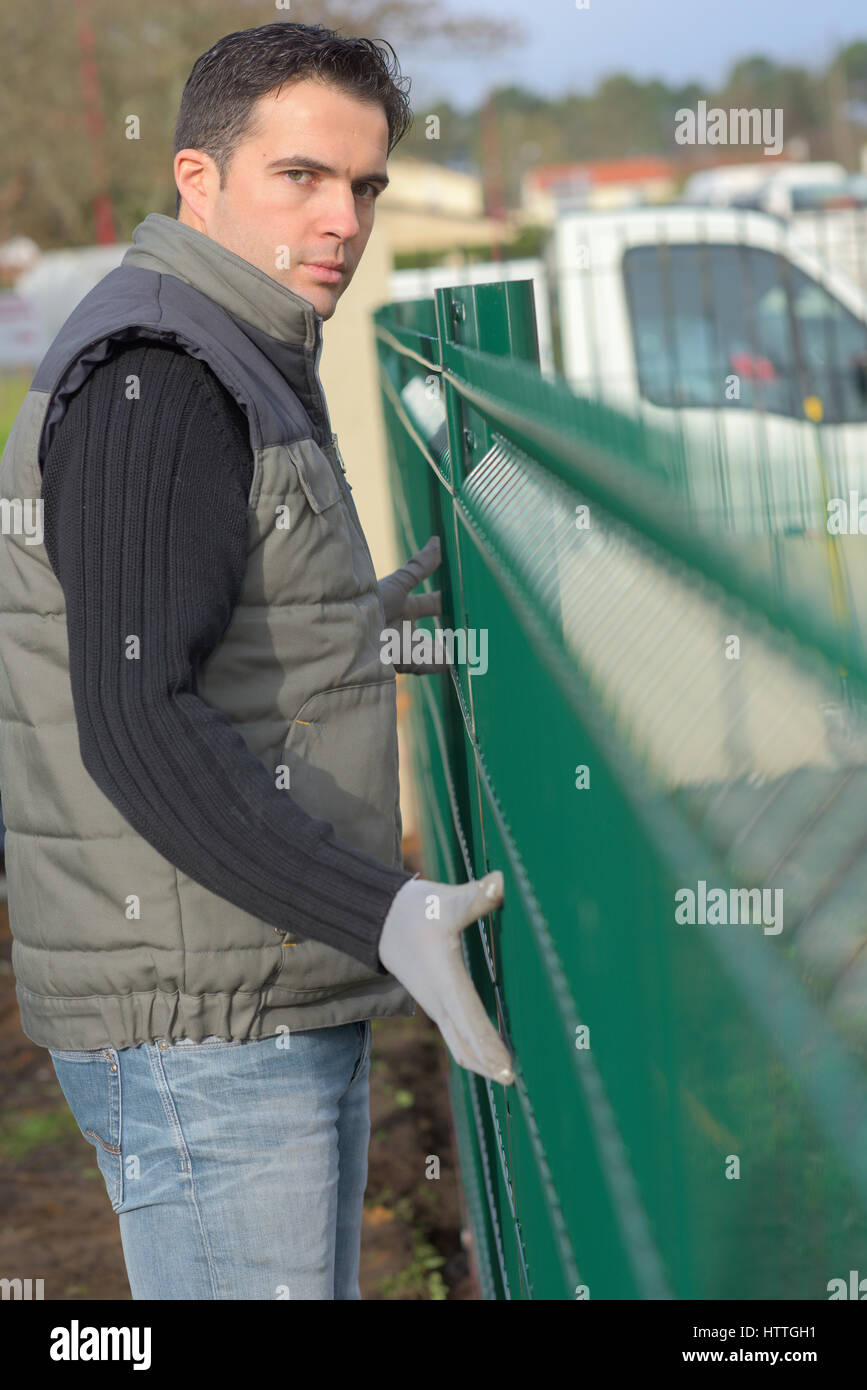 worker erecting a fence Stock Photo - Alamy