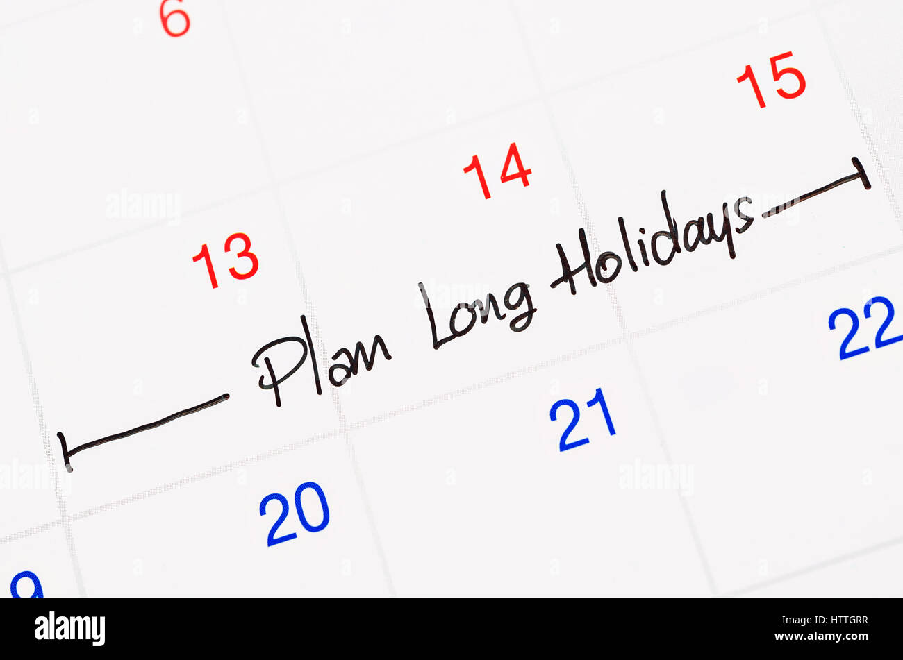 Plan long holidays word written on a white calendar page to remind ...