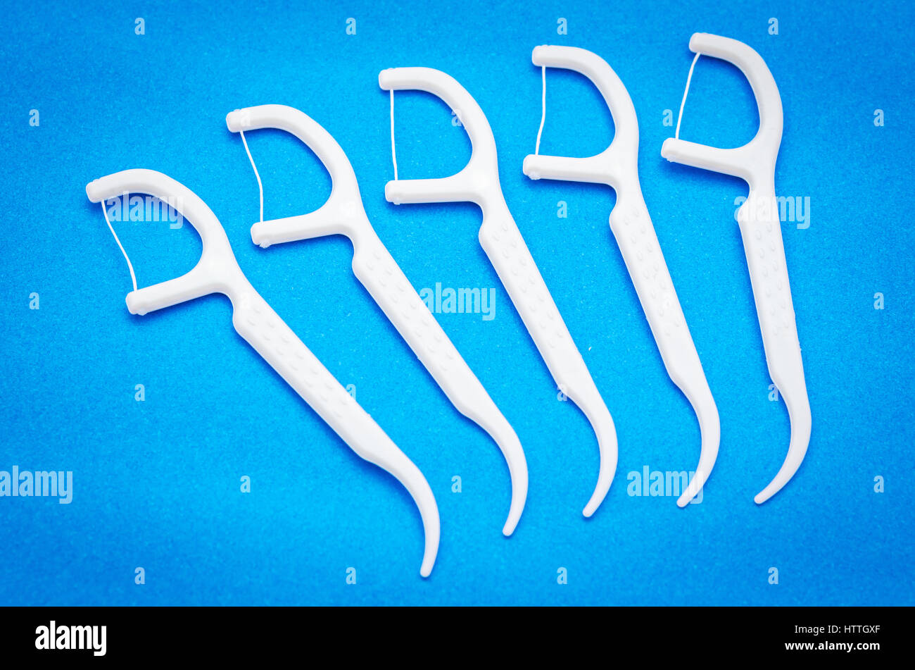 White Dental floss on blue background Stock Photo - Alamy