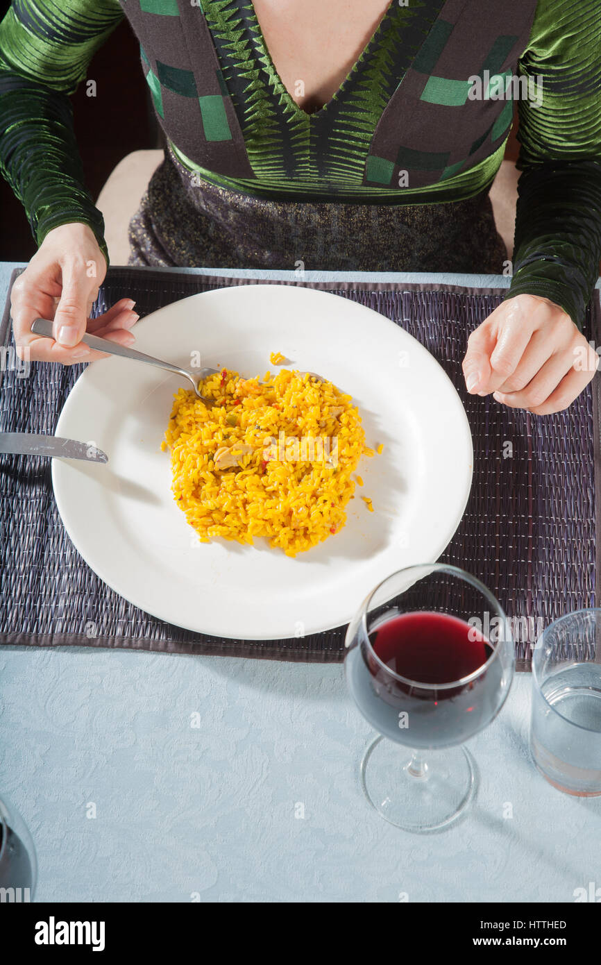 aerial view of woman with green dress eating paella, Spanish typical ...