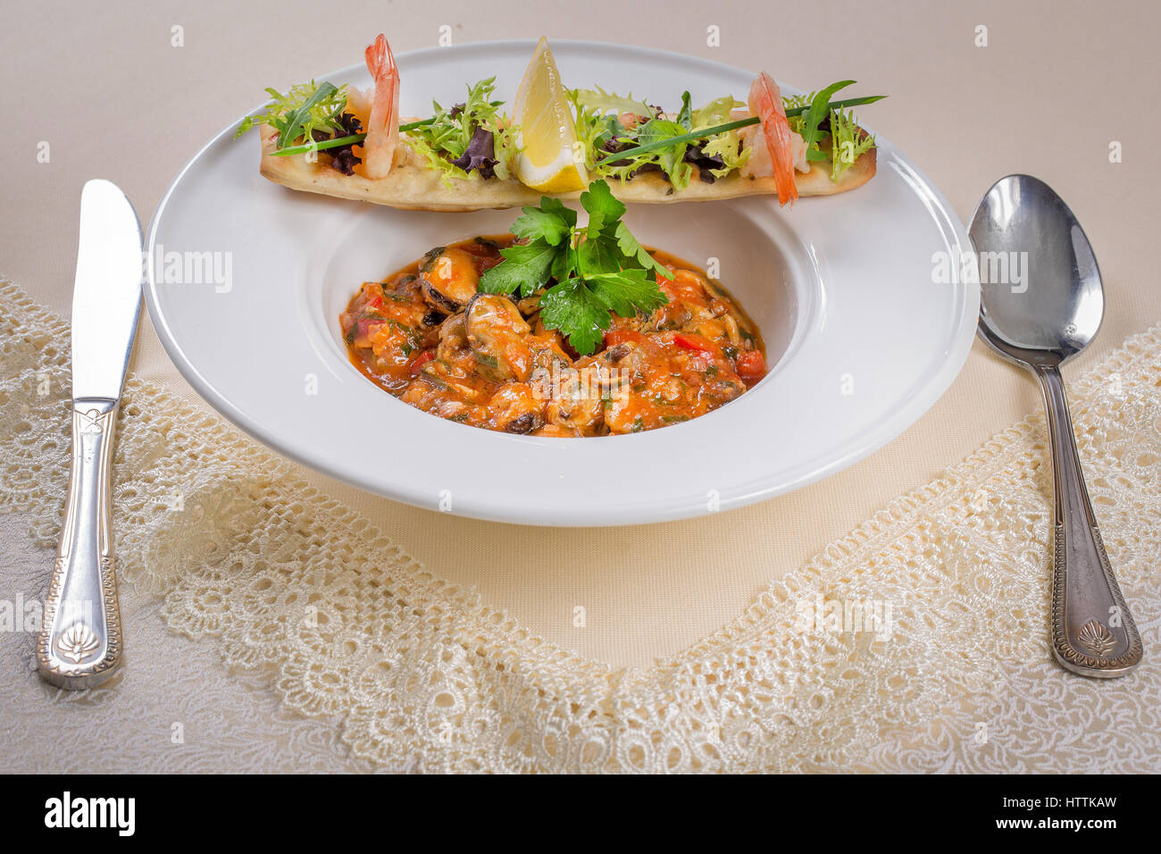 Mussels cooking with lemon and herbs in clay pot over dark wood ...