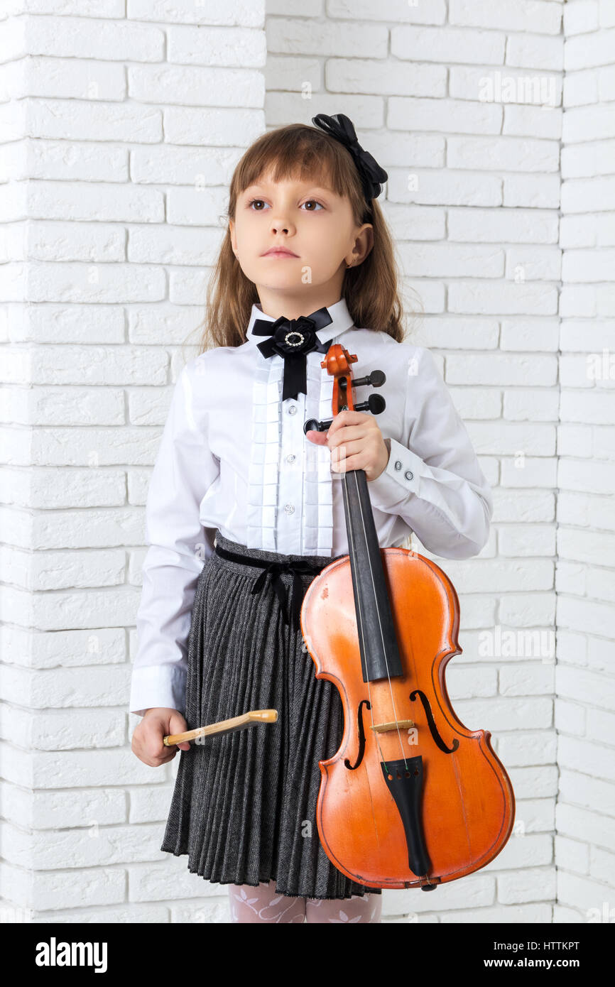 Little girl standing and holding fiddle Stock Photo - Alamy