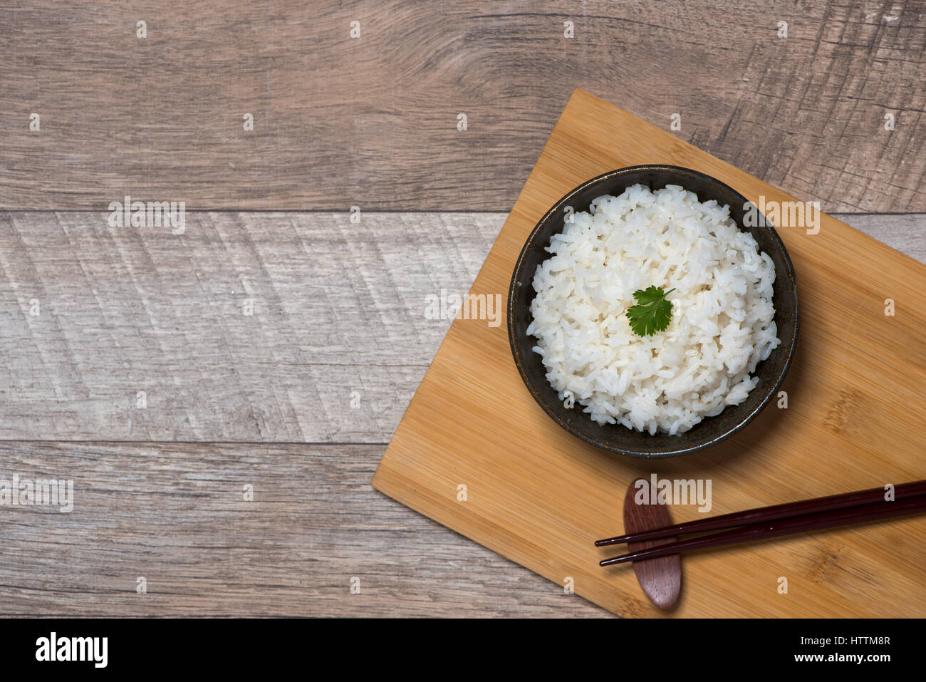 Boiled rice in a bowl on wooden table Stock Photo - Alamy