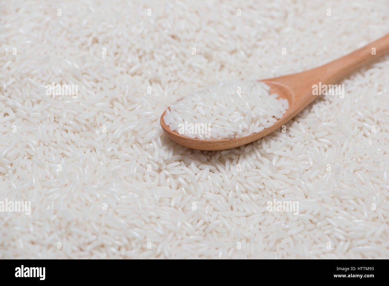 White rice in a wooden spoon. top view Stock Photo - Alamy