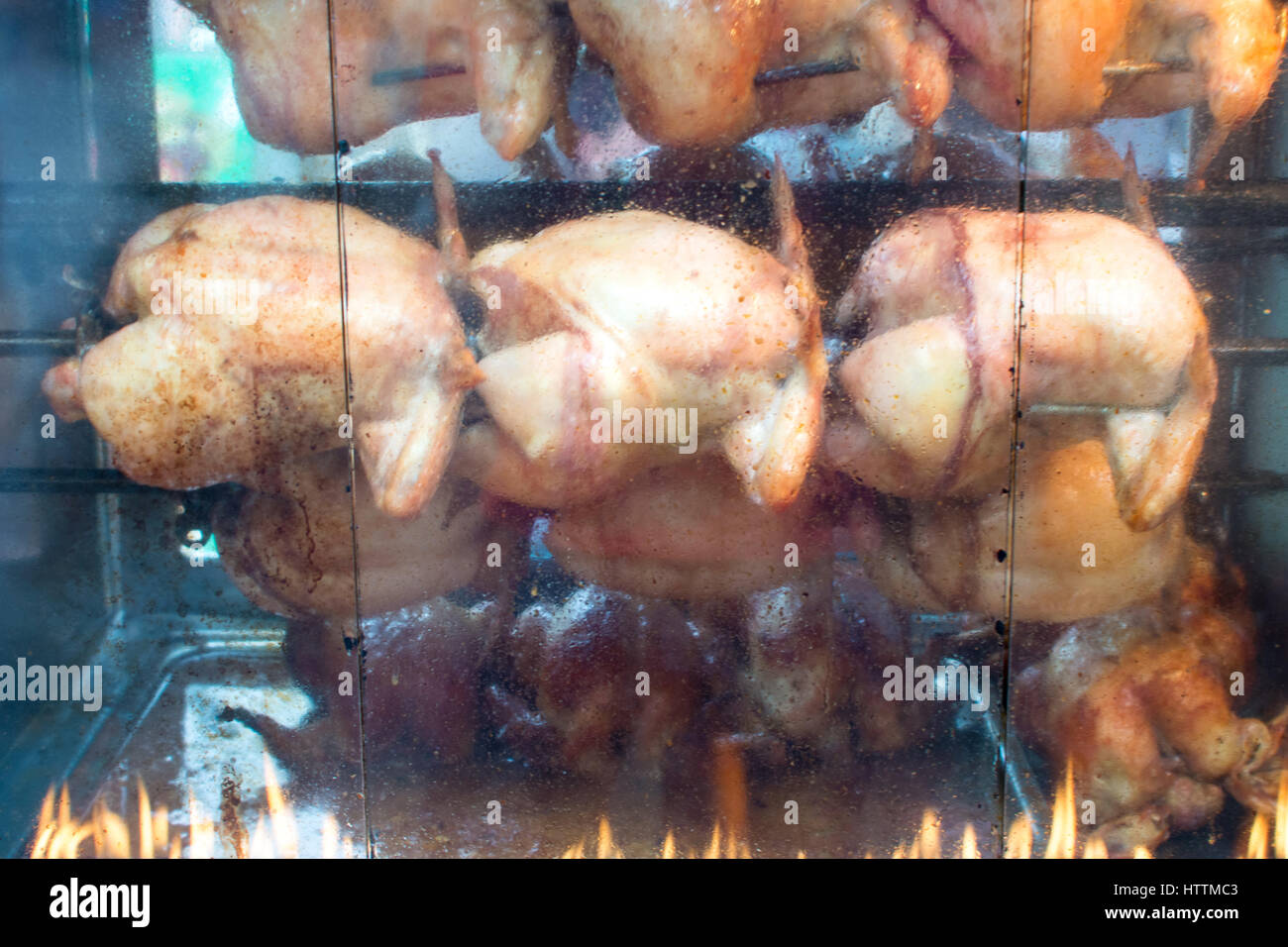 Chicken roasting above fire on rotating stick Stock Photo - Alamy