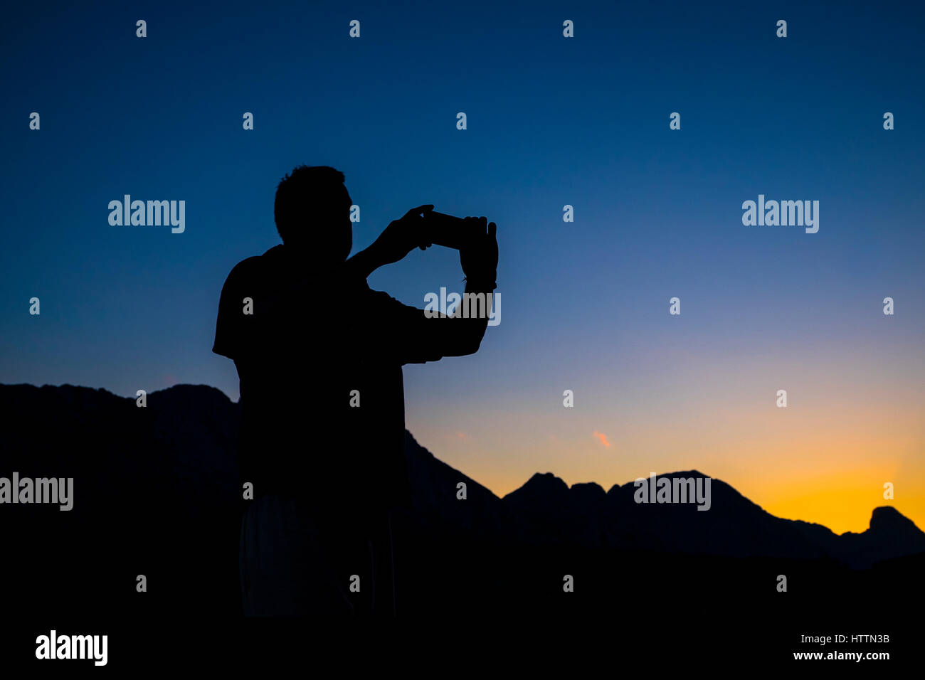 Man silhouette in the mountains with a smartophone in Basque Country ...