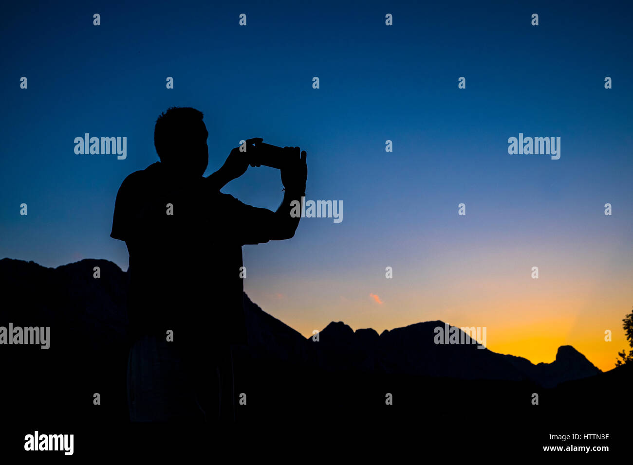 Man silhouette in the mountains with a smartophone in Basque Country ...