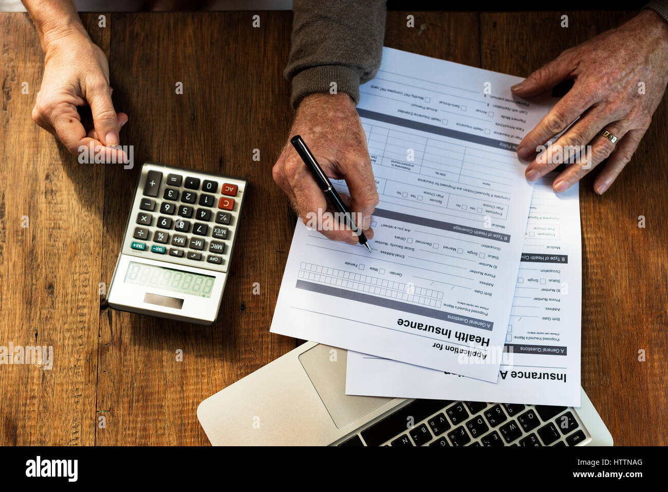 Insurance Mature Signing Application Form Stock Photo - Alamy