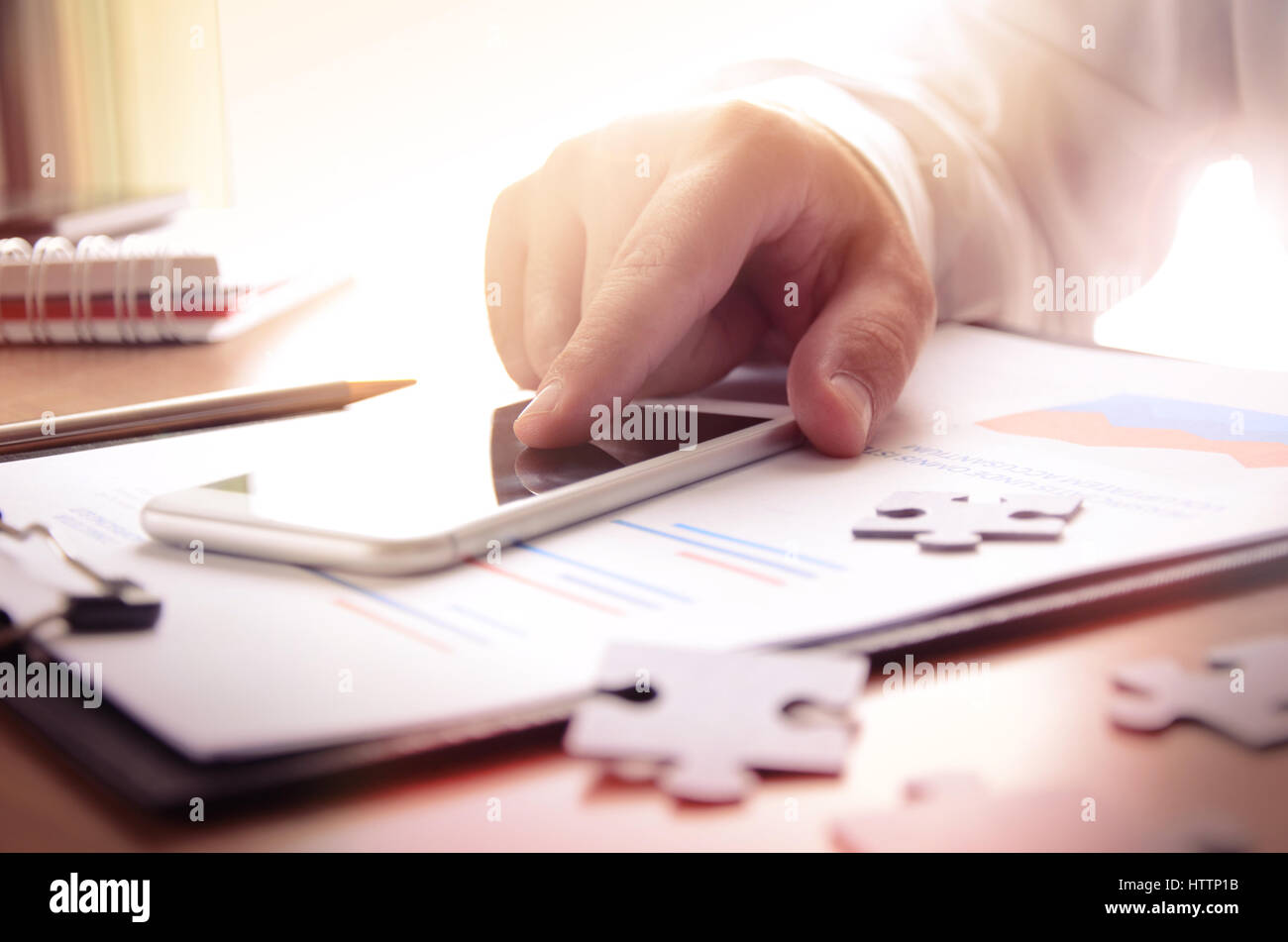 Office desktop with hand using mobile phone, paperwork, stationary and ...